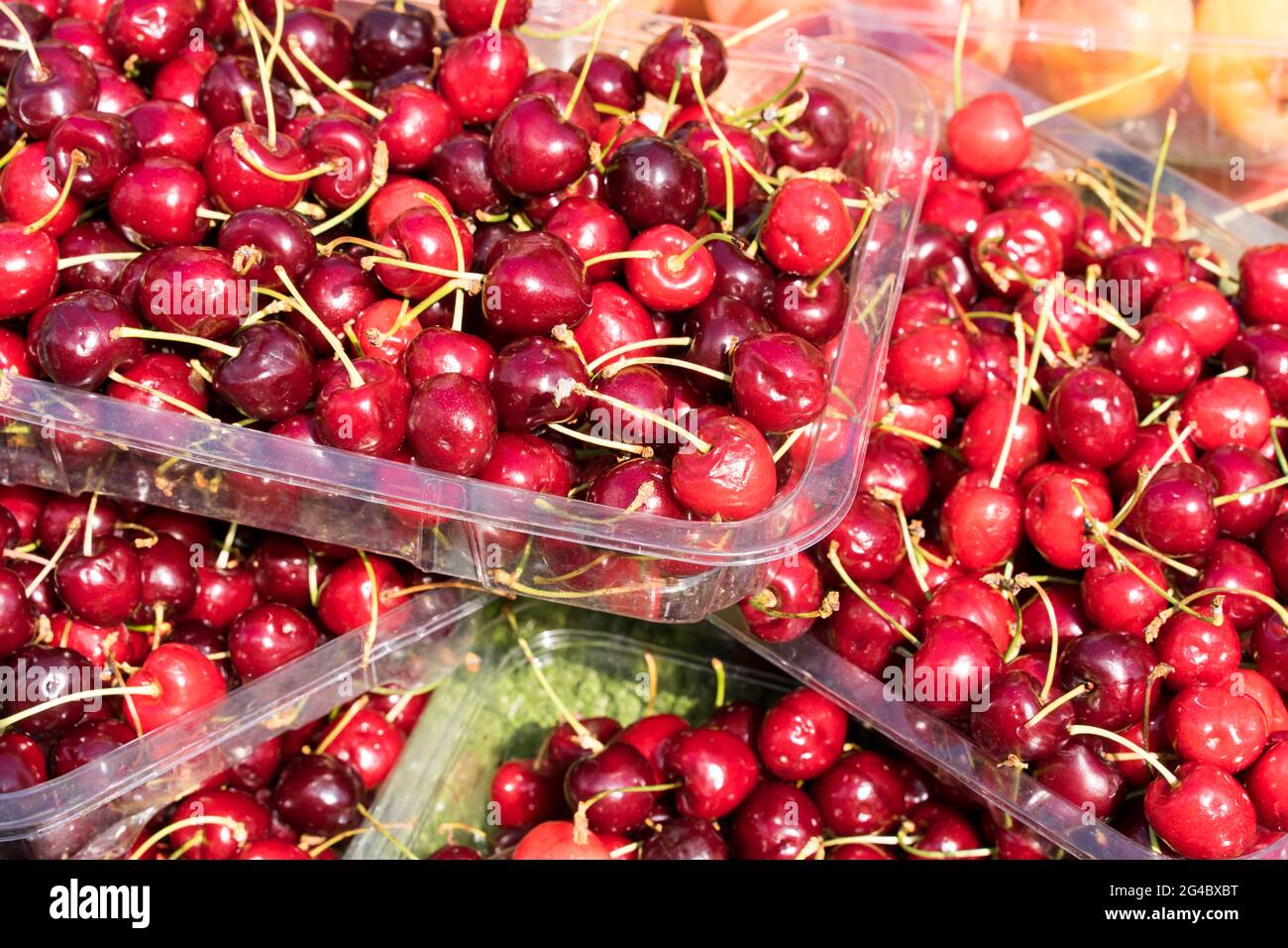 stack of cherry in containers for sale at flee market stall, London ...
