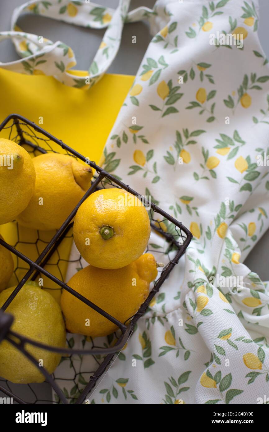 A lemon in vertical position inside a wire metallic basket with more ...