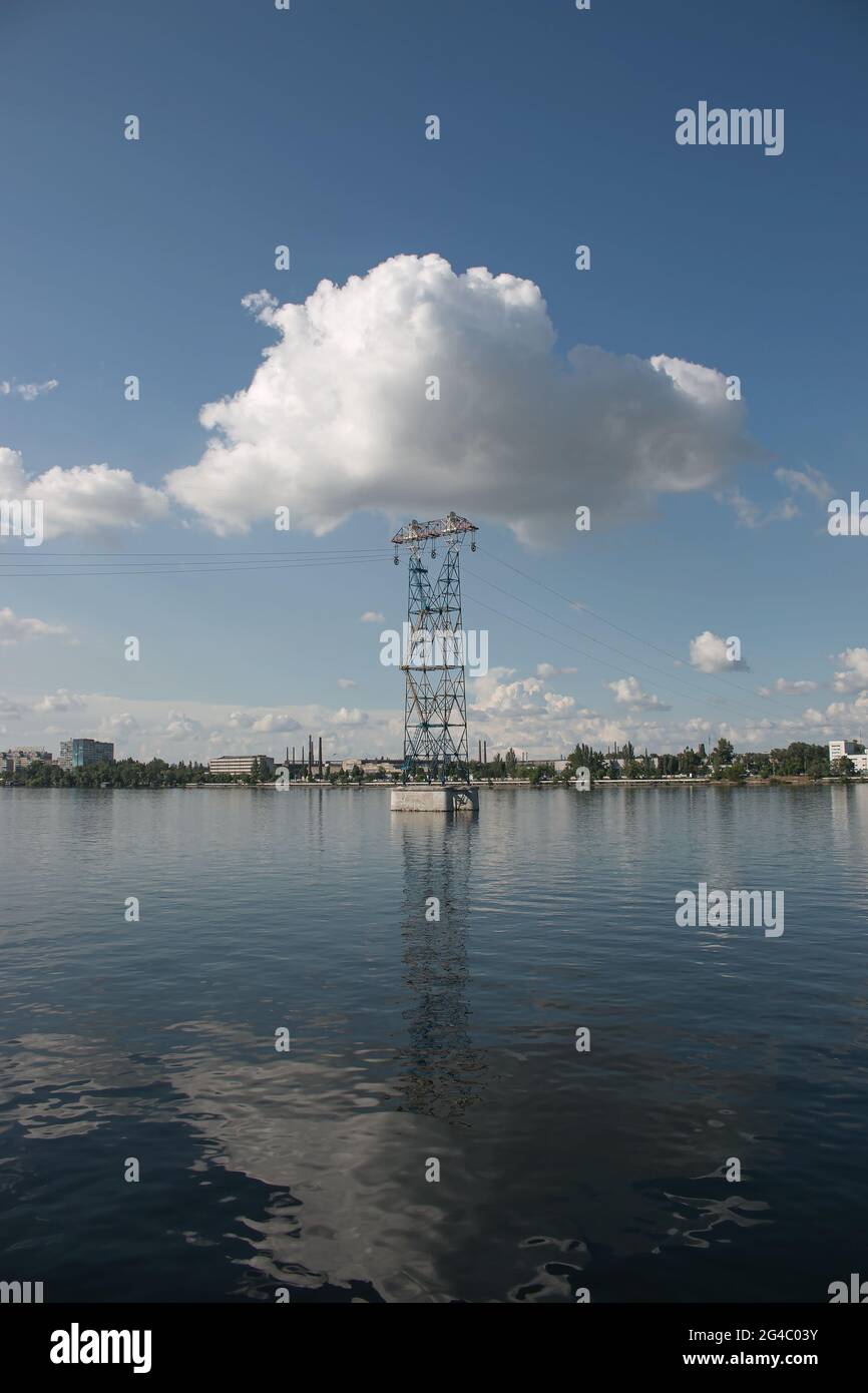 High-voltage pylons of power lines on the river. Metal pylons of high ...