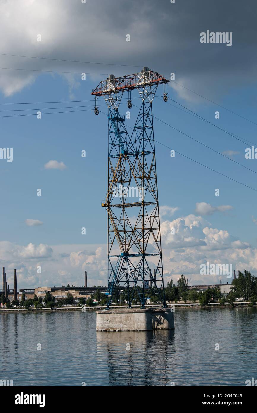 High-voltage pylons of power lines on the river. Metal pylons of high ...