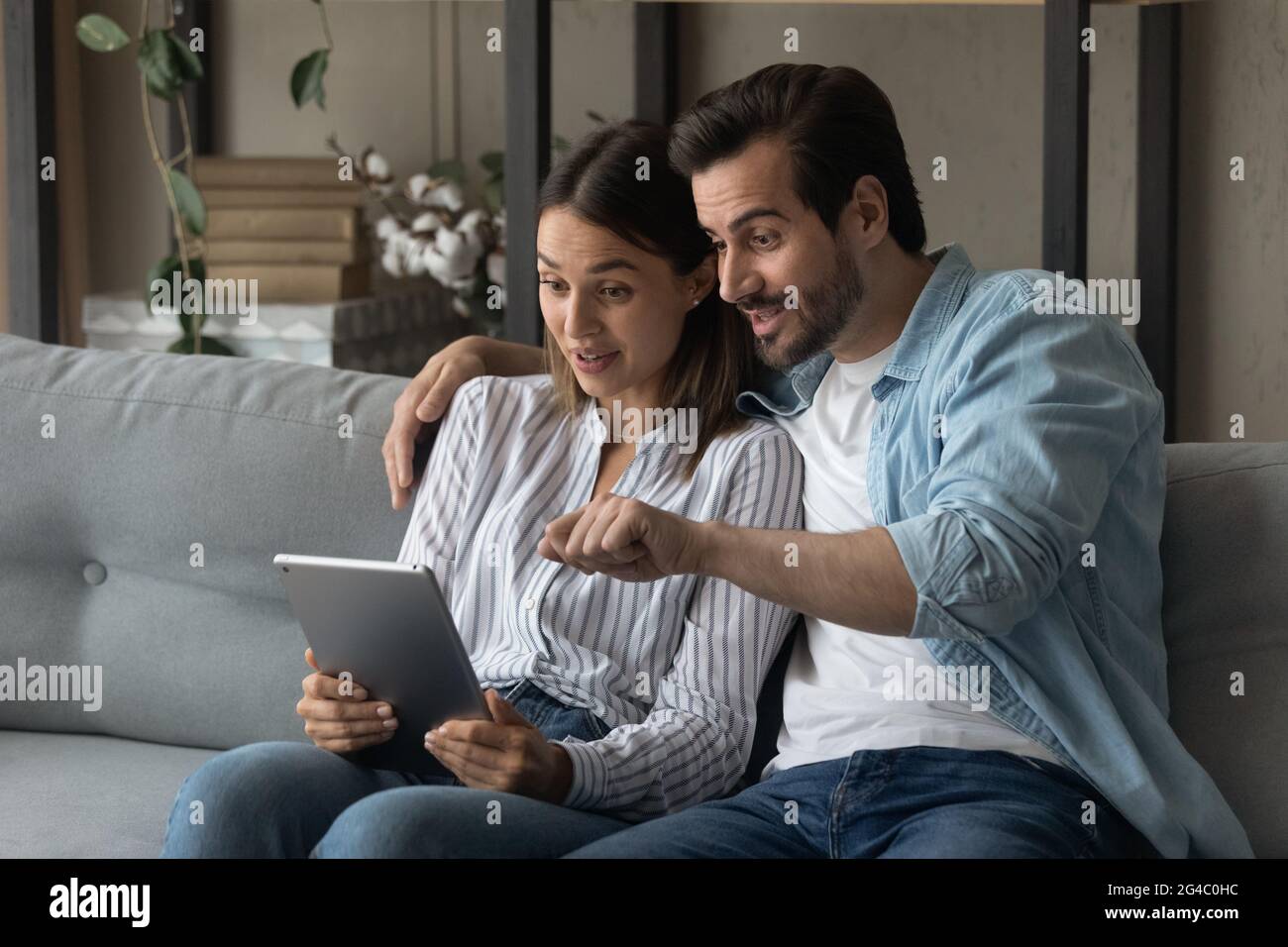 Surprised young happy couple looking at digital computer tablet Stock ...