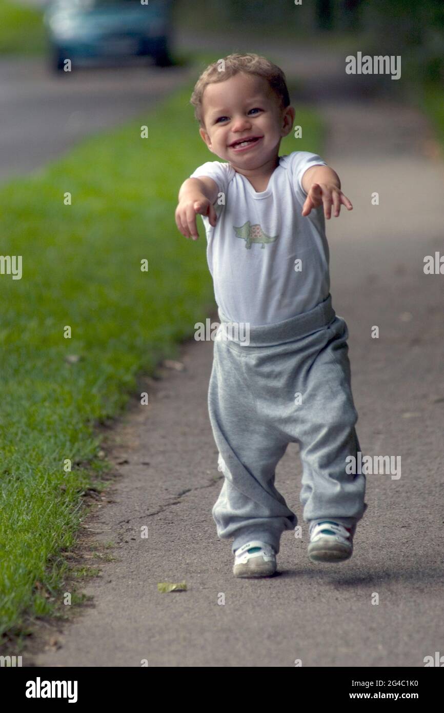 happy little toddler boy taking his first steps outdoors Stock Photo ...