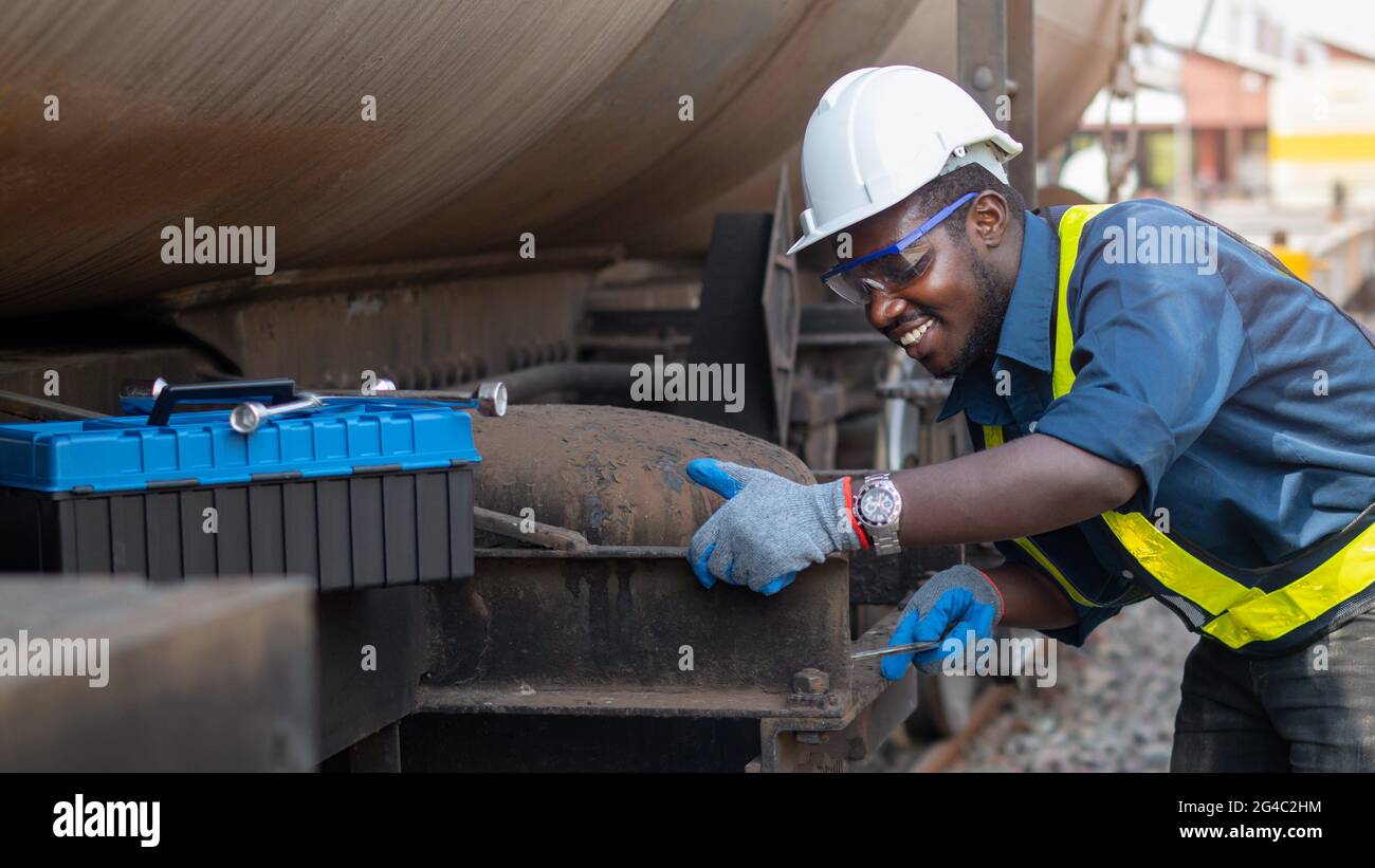 African machine engineer technician wearing a helmet, groves and safety ...