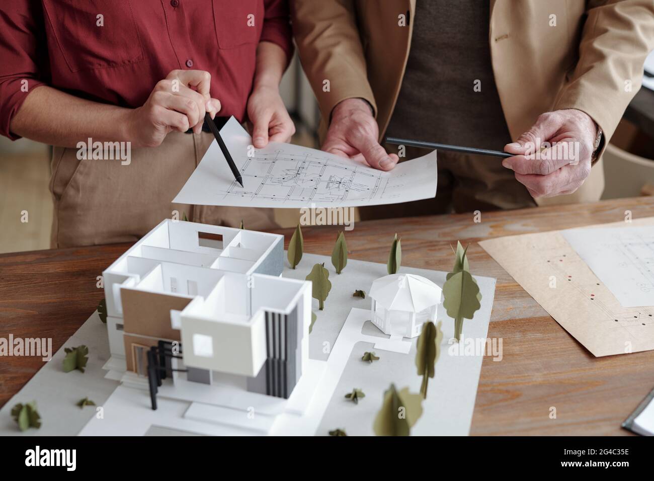 Close-up of unrecognizable woman pointing at house plan while ...