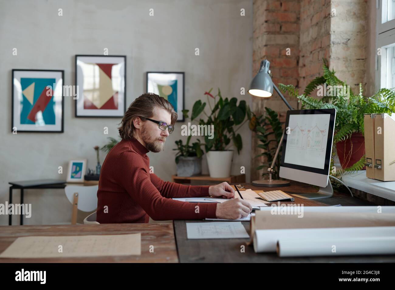 Busy concentrated Caucasian architectural designer with beard sitting ...