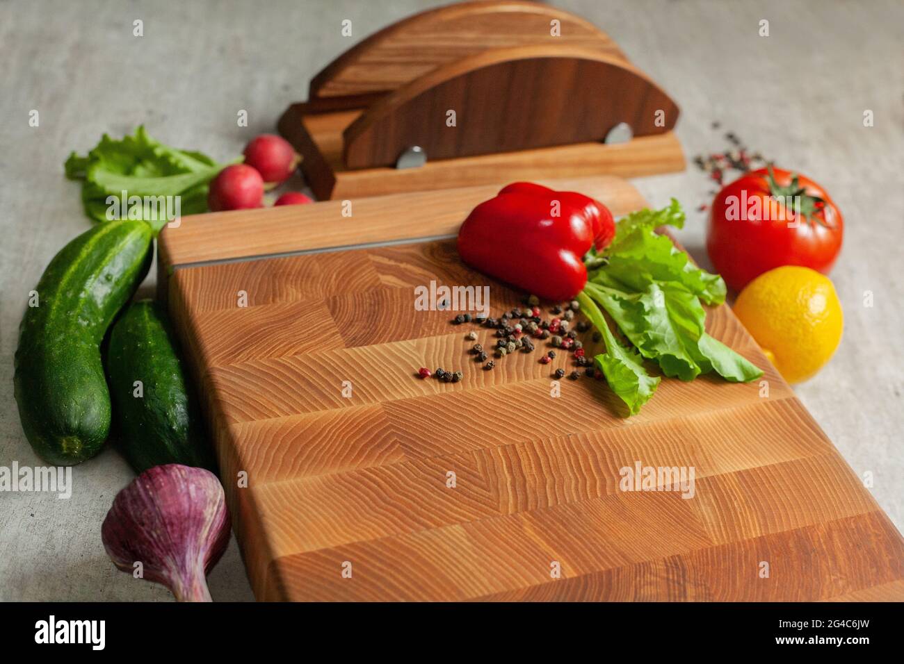 wooden plank with vegetables and spices on a light and dark background ...