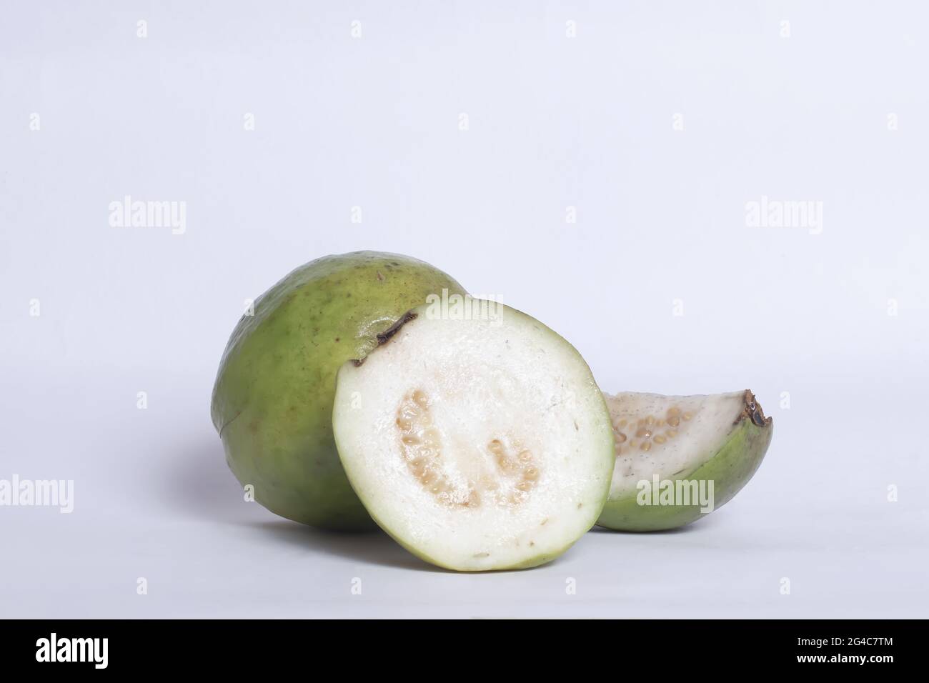 A full and sliced fresh, green guavas with a white background Stock ...