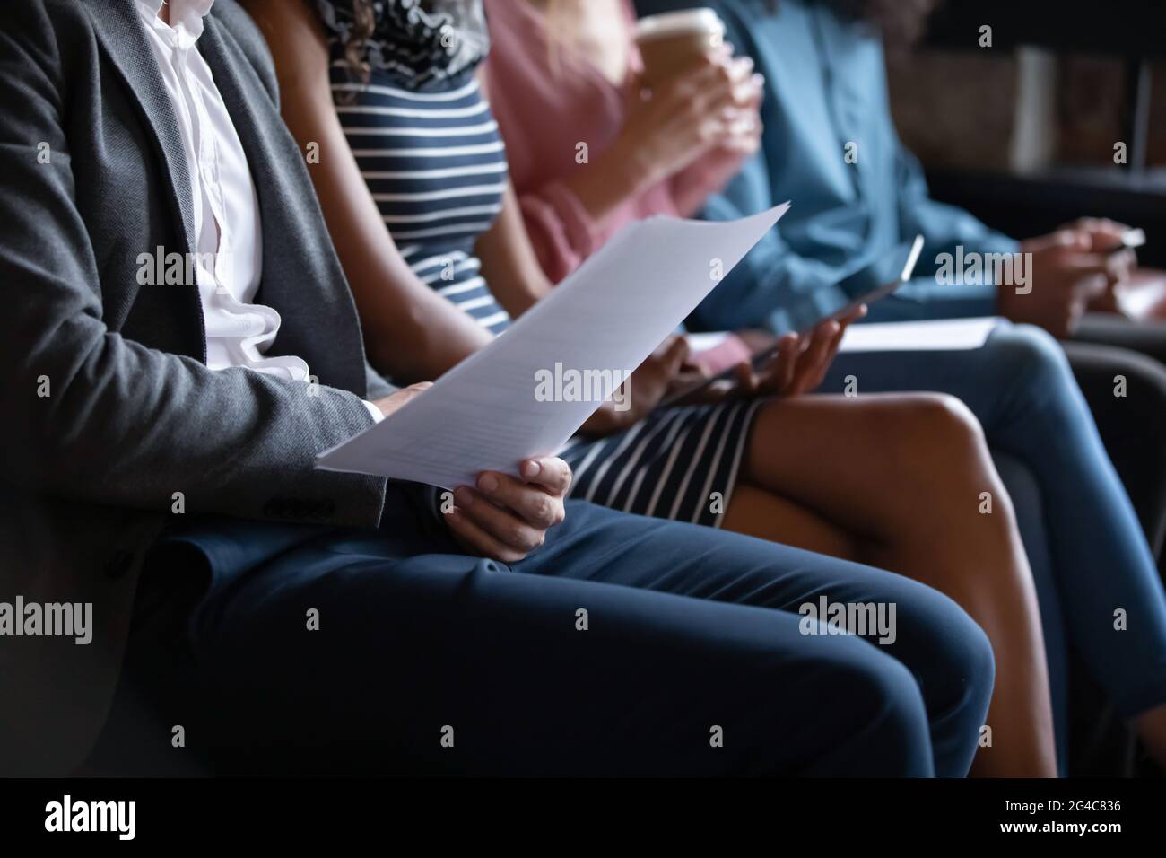 Closeup unrecognizable young multiracial people sitting in line on sofa ...