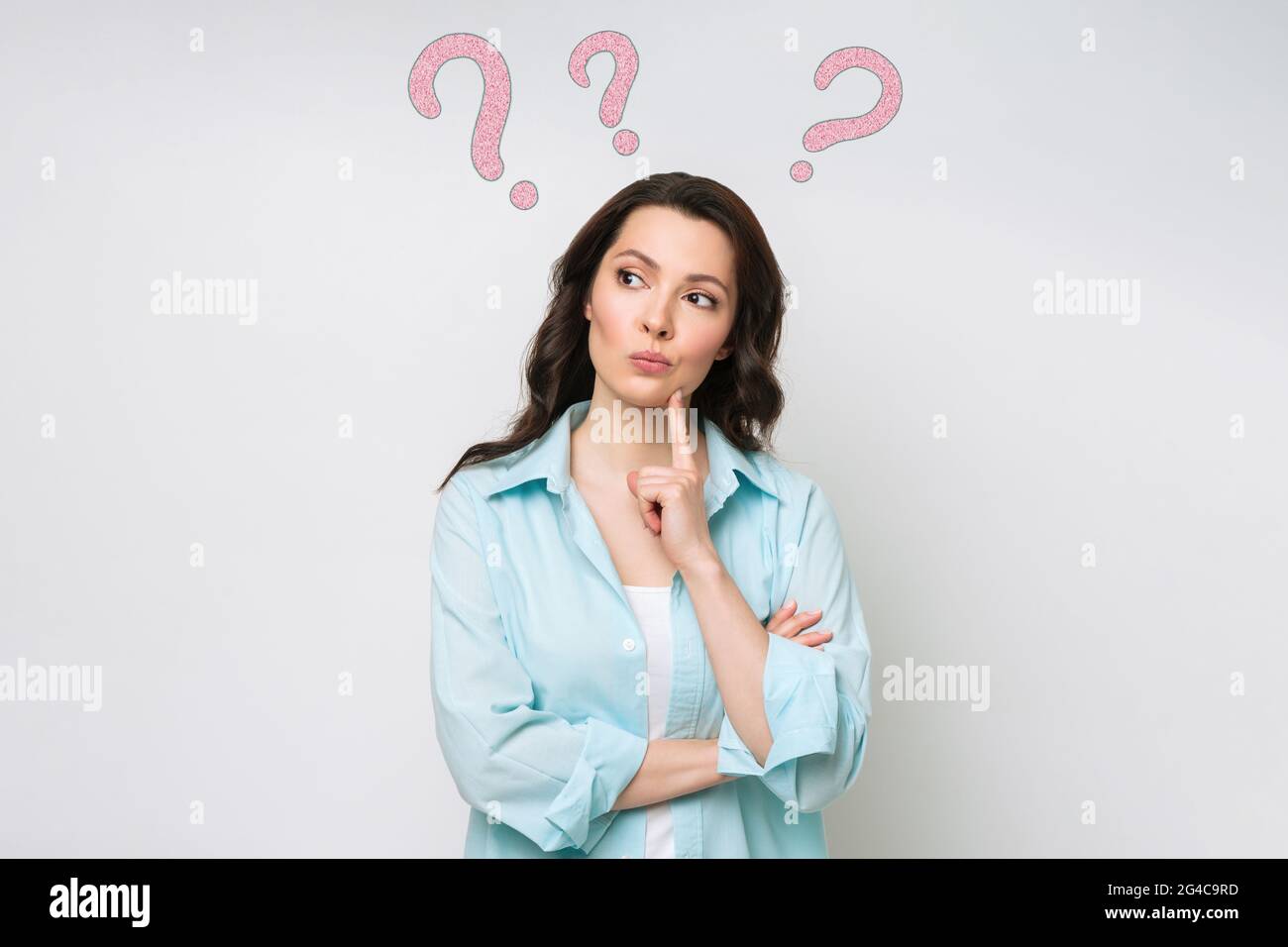 A confused woman stands uncertainly, shrugs her shoulders, can't give ...