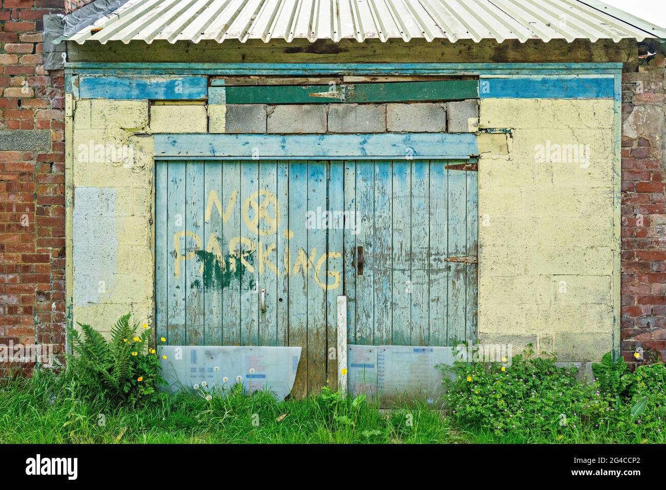 Blue painted wooden doors to building in back lane Stock Photo - Alamy