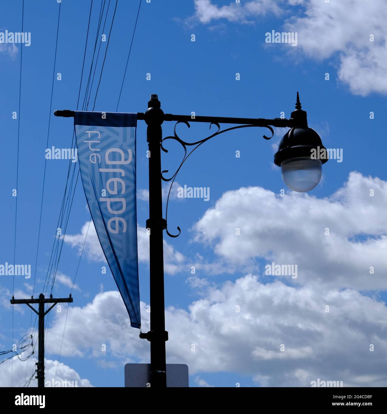 Lamp post blue flag declaring "the glebe" with a blue sky and fluffy ...