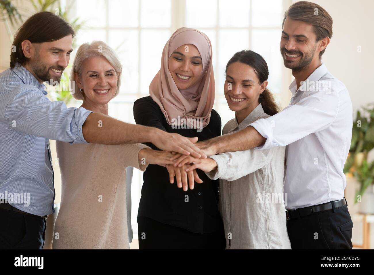 Happy smiling diverse employees putting hands together at meeting Stock ...