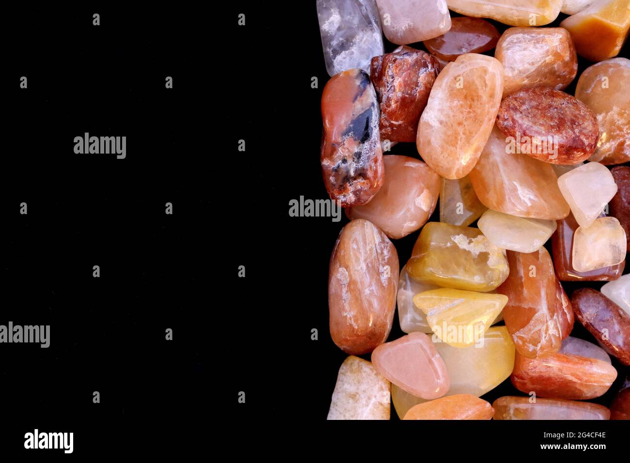 Red silk jade heap jewel stones texture on half black background. Place ...