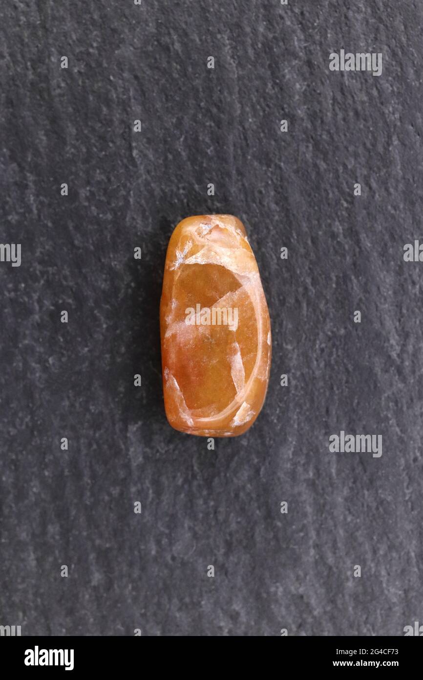 Red silk jade jewel stone texture on black stone background. Macro ...
