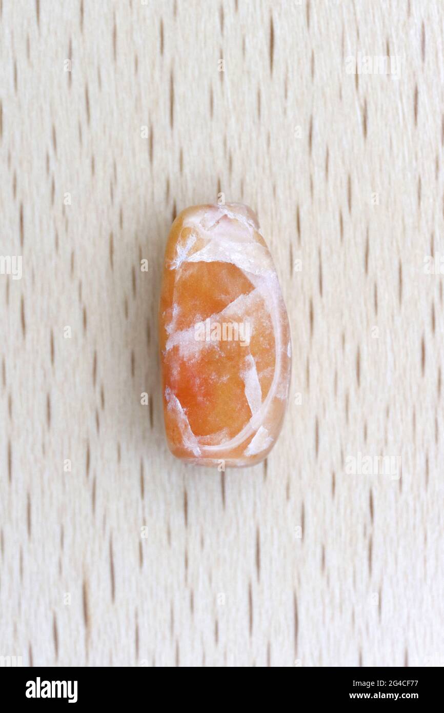 Red silk jade jewel stone texture on light varnished wood background ...