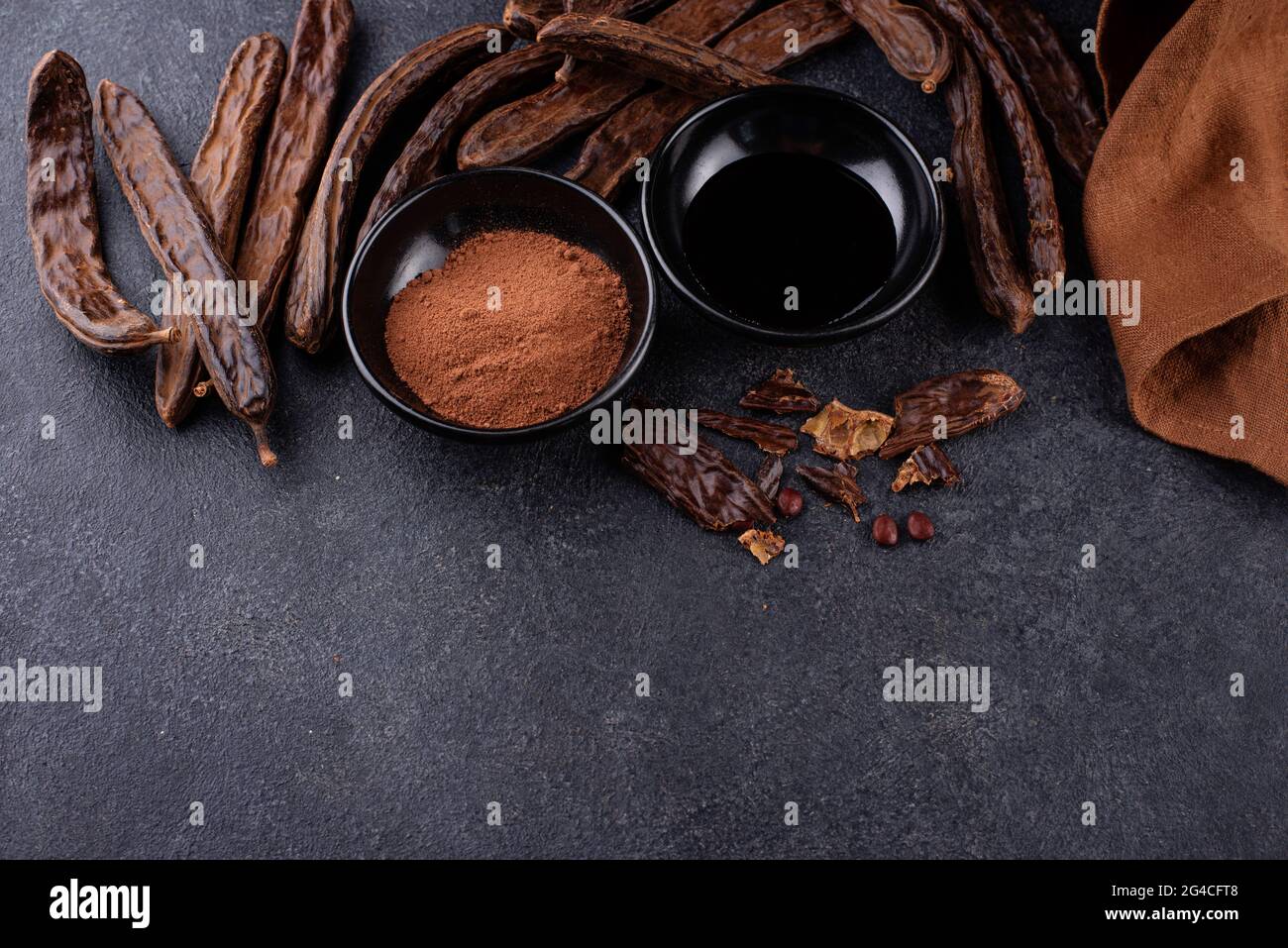 Carob pods, powder and molasses or syrup Stock Photo - Alamy