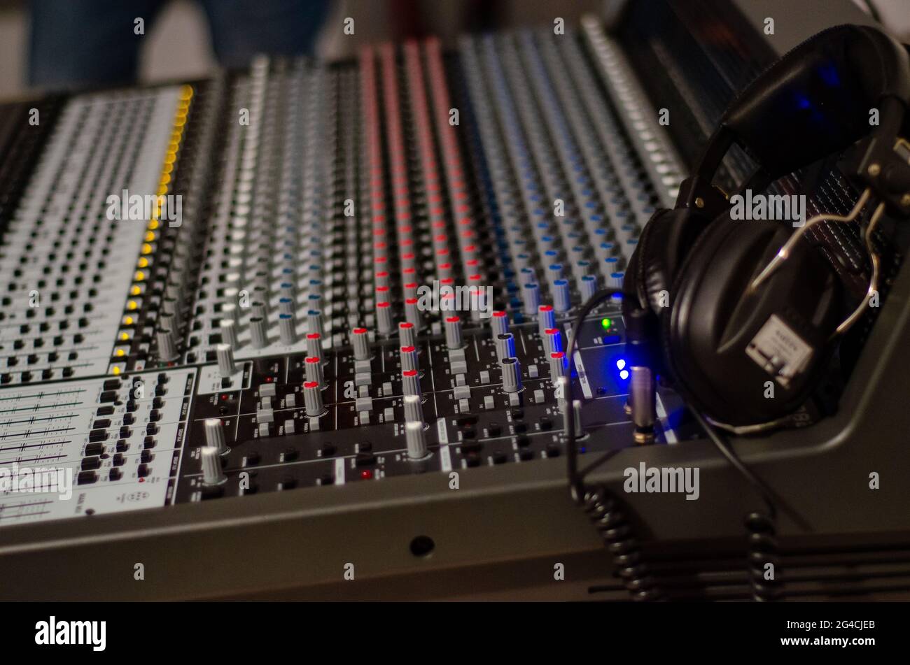 A shallow focus shot of a recording studio mixing console with black ...