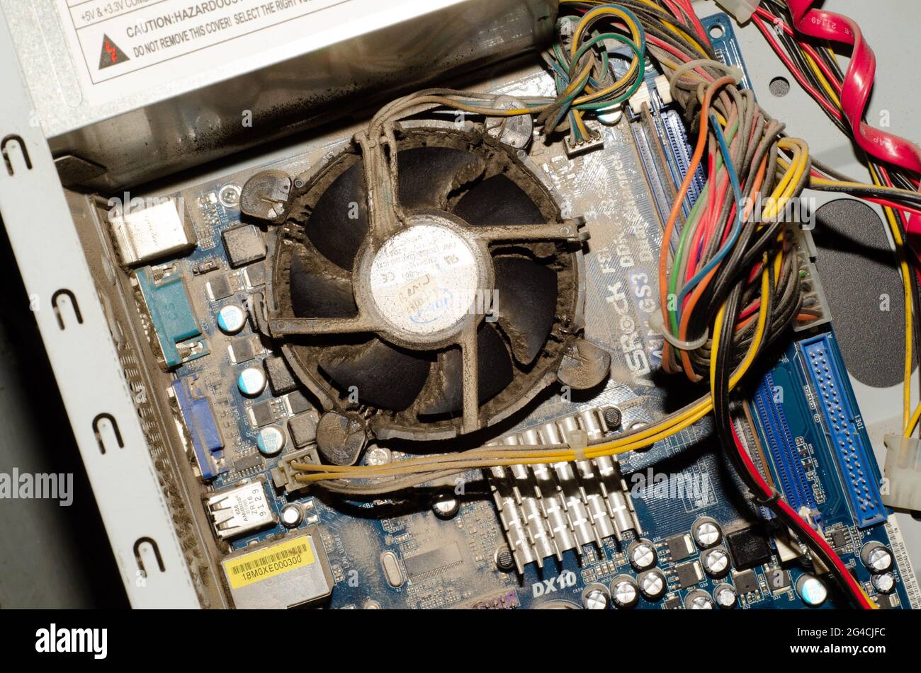 A shot of an old processor cooler in a system block with colorful wires ...