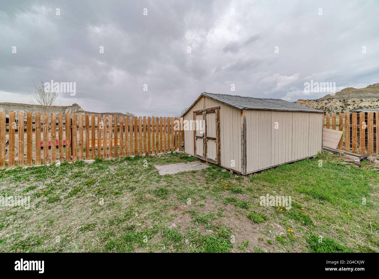 A view of an old barn in a fenced territory under a cloudy sky Stock ...