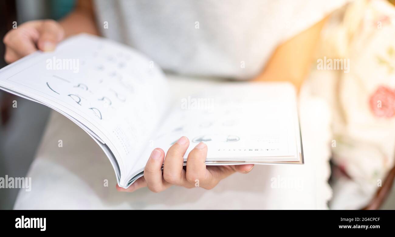 Female hand holding pattern book of cross-stitch that step by step for ...