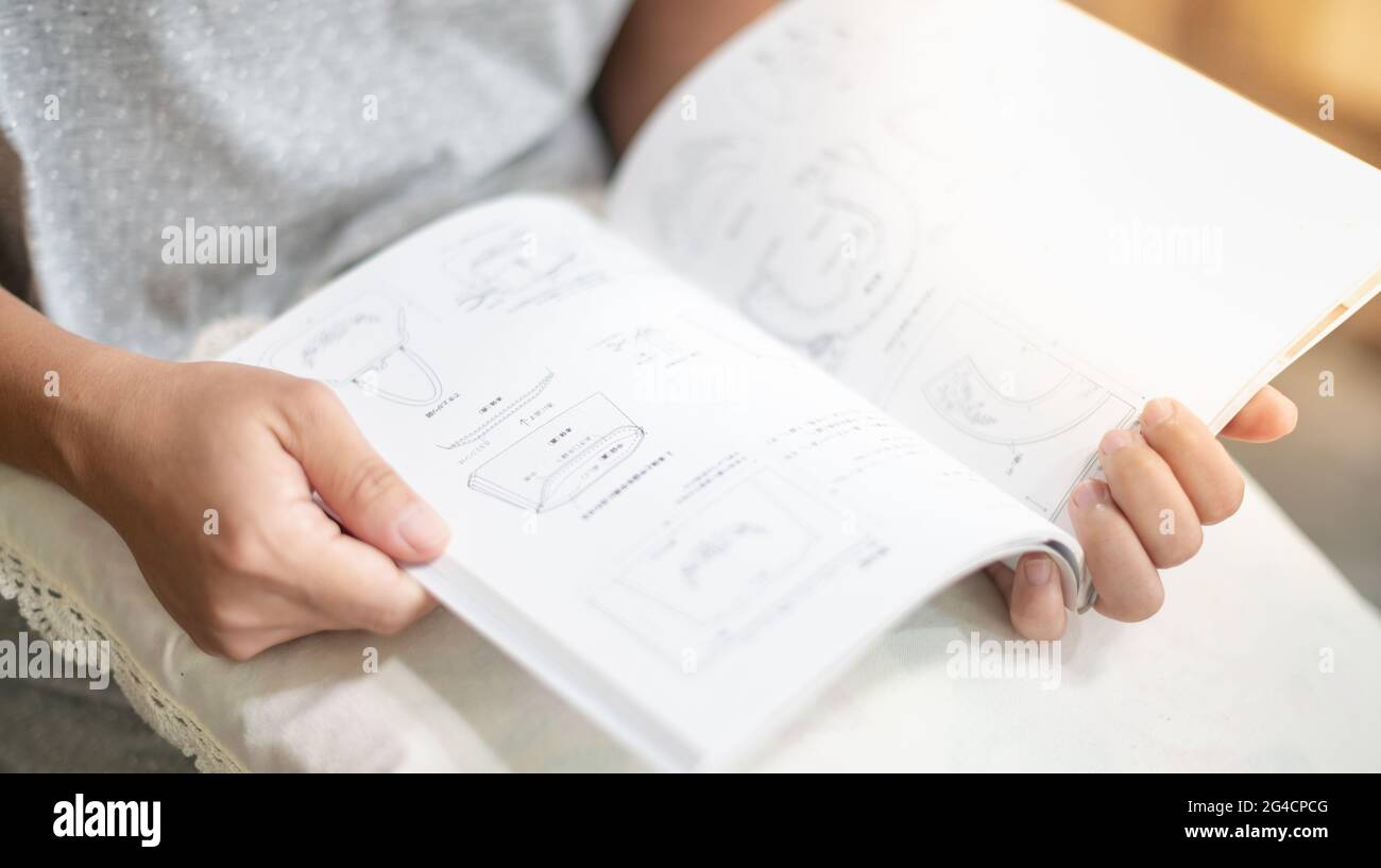 Female hand holding pattern book of cross-stitch that step by step for ...