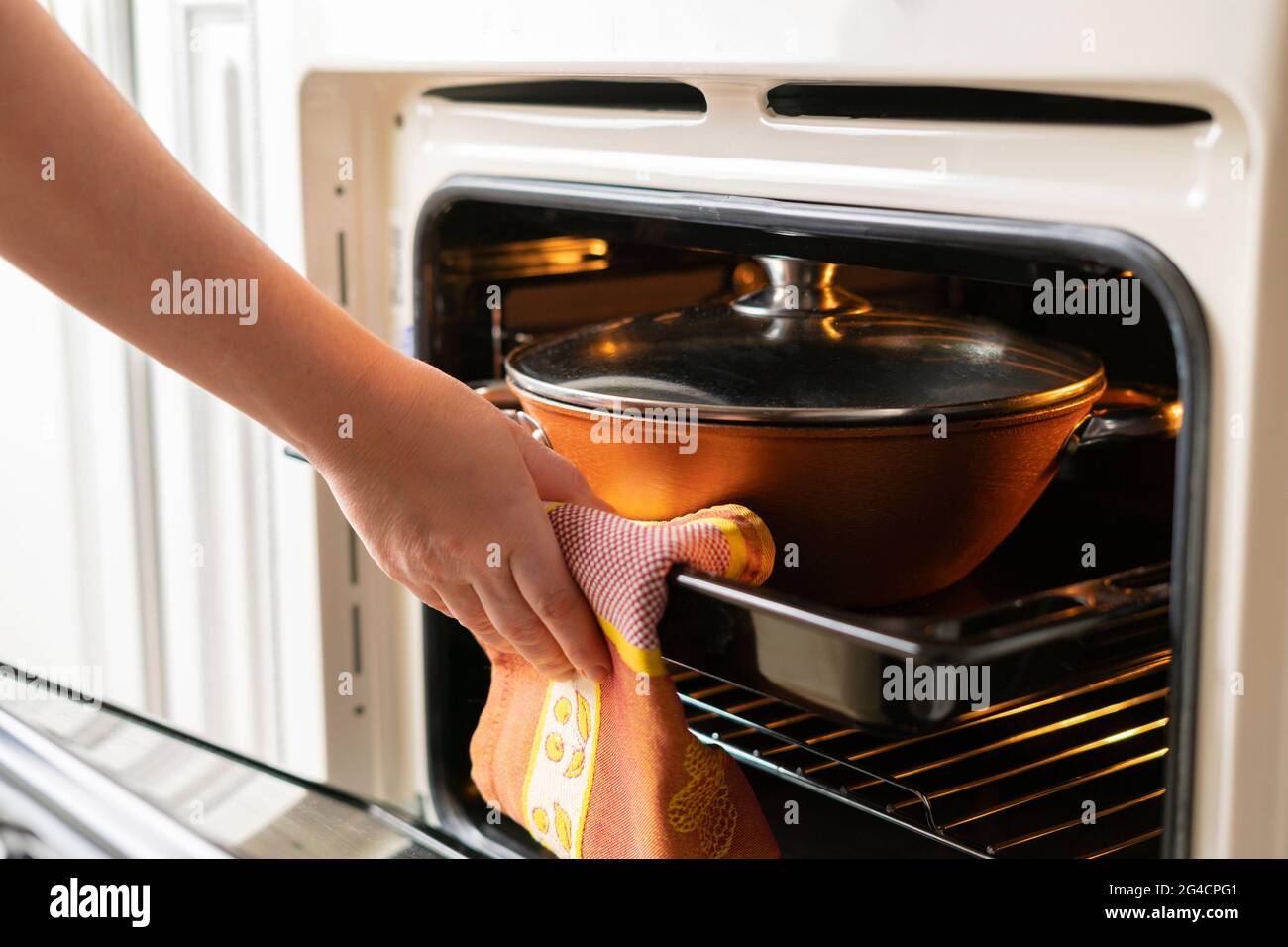 close up woman hands open the oven and take out fresh cooked food at ...