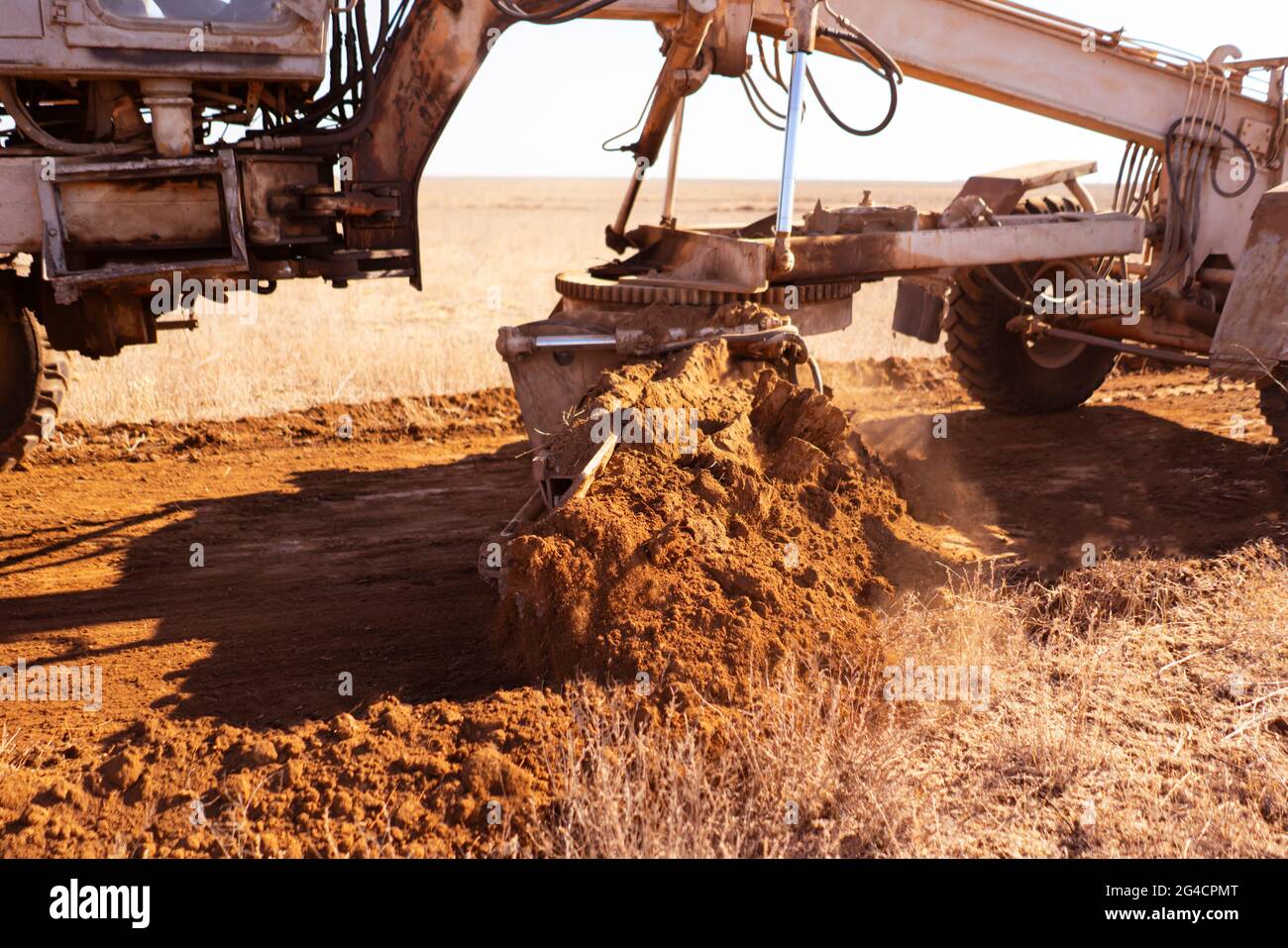 close up grader scoop dig the dirt on summer day, making a parapet ...