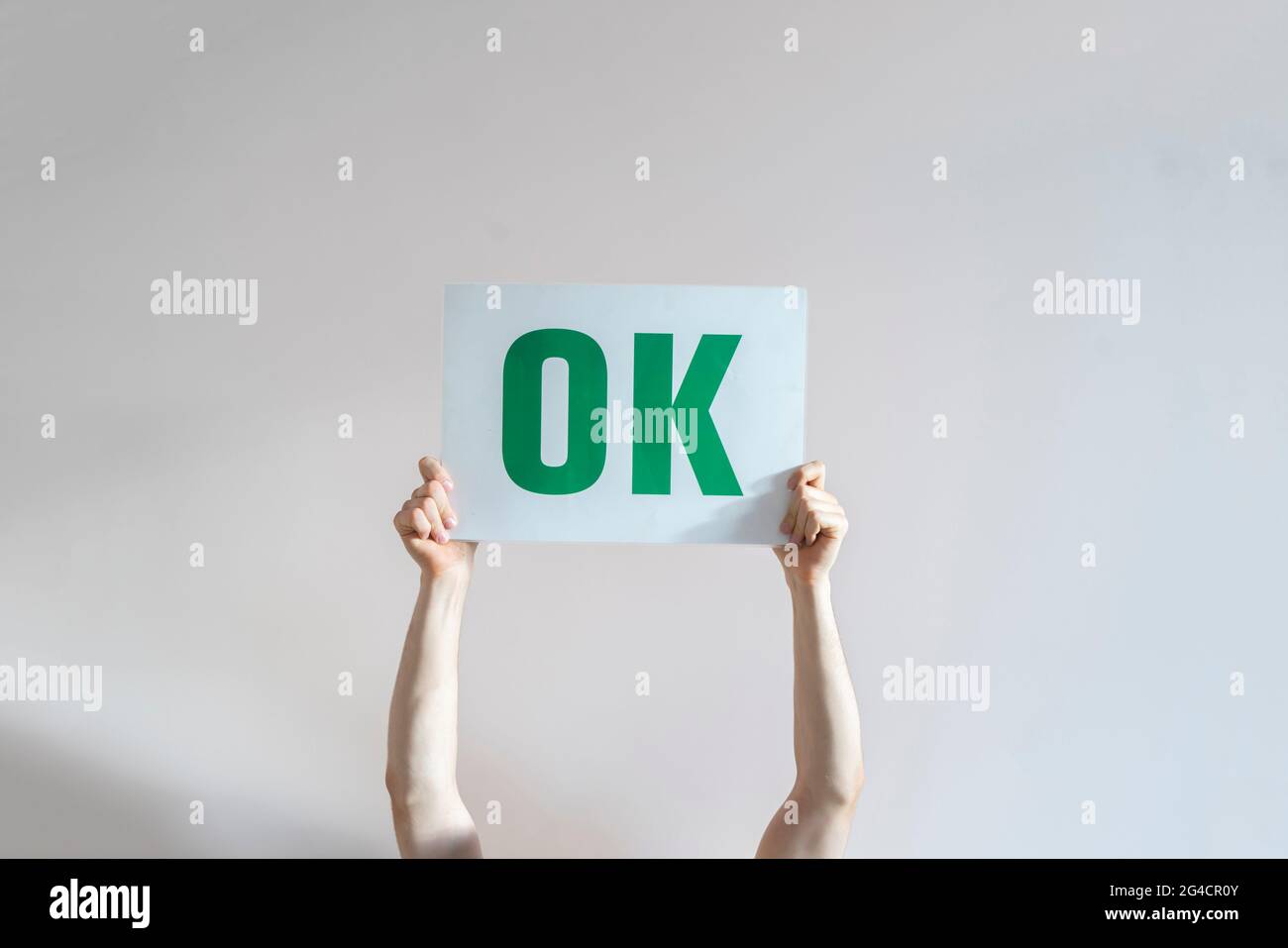 person's hands holding plate with ok word sign, positive simple design ...