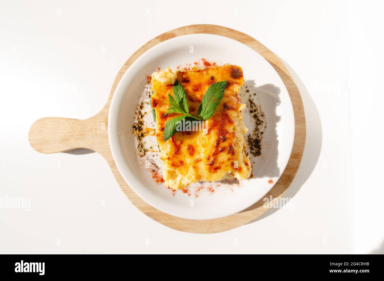 Top view of a slice of delicious lasagne on a round cutting ...