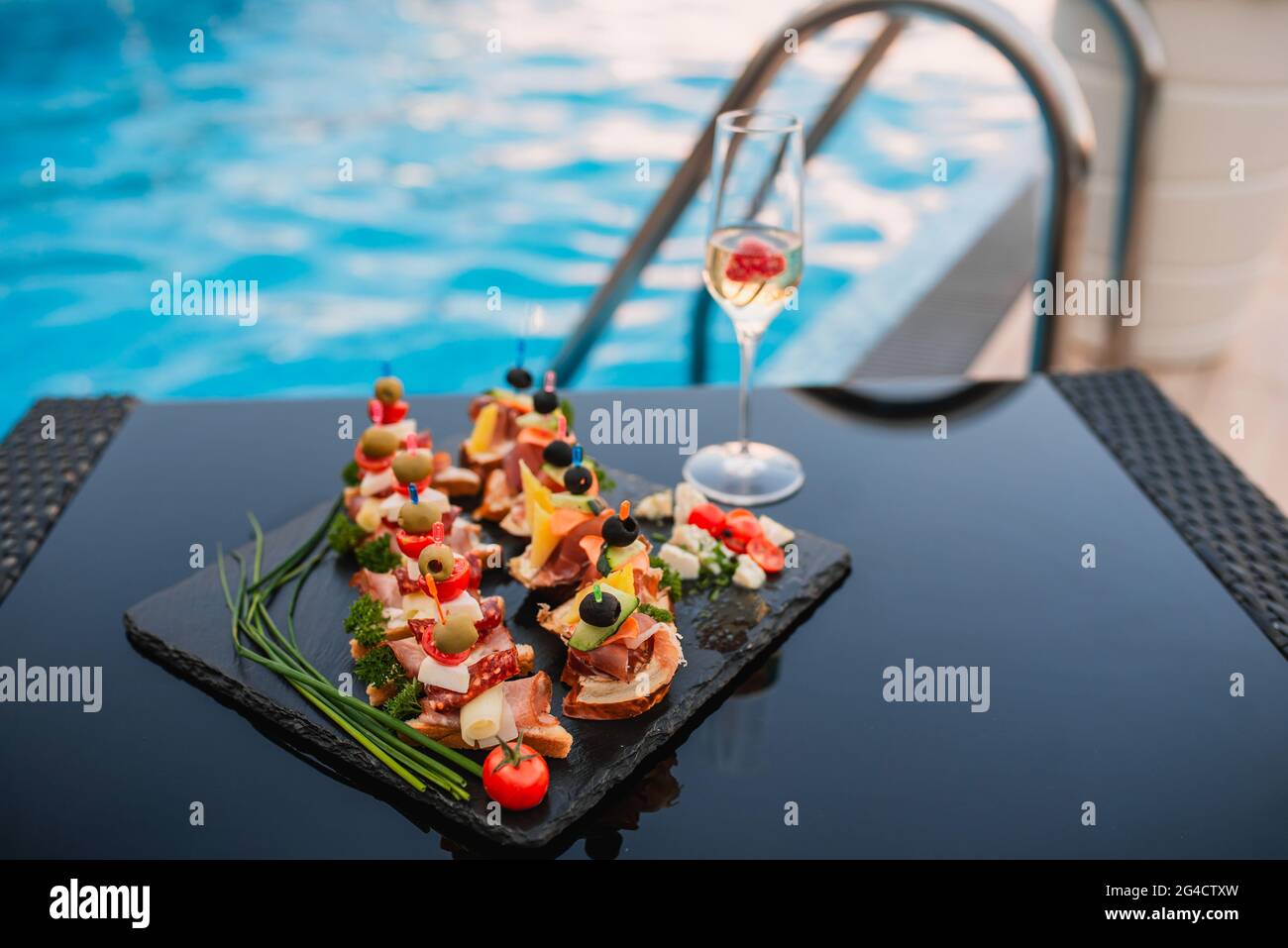 Canapes placed on a tray, while next to the champagne with strawberries ...