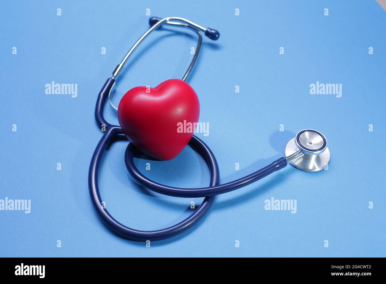Red heart shape and stethoscope on blue background Stock Photo - Alamy