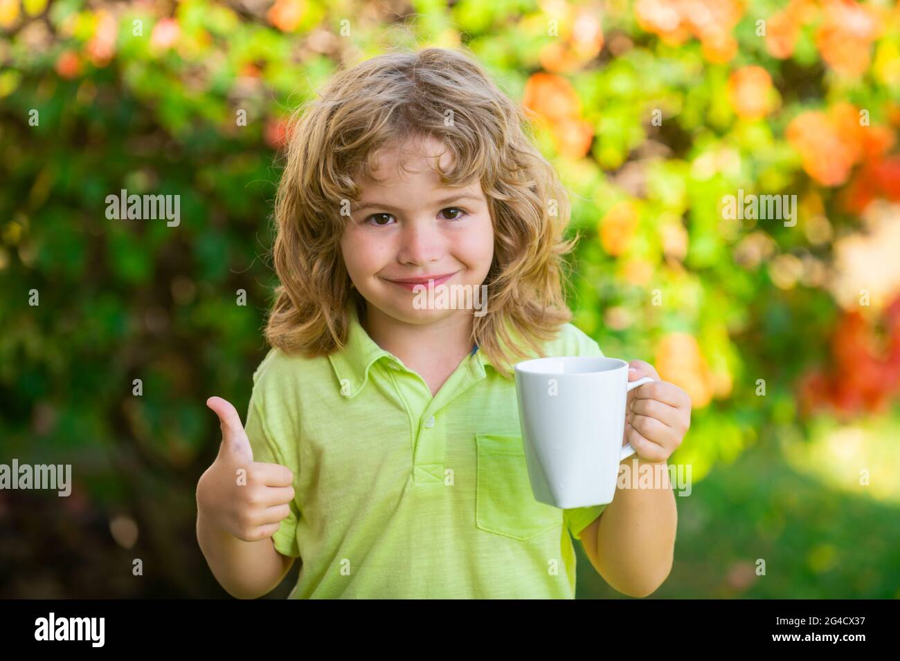 Child drinking tea or water in backyard garden. Healing kids and ...
