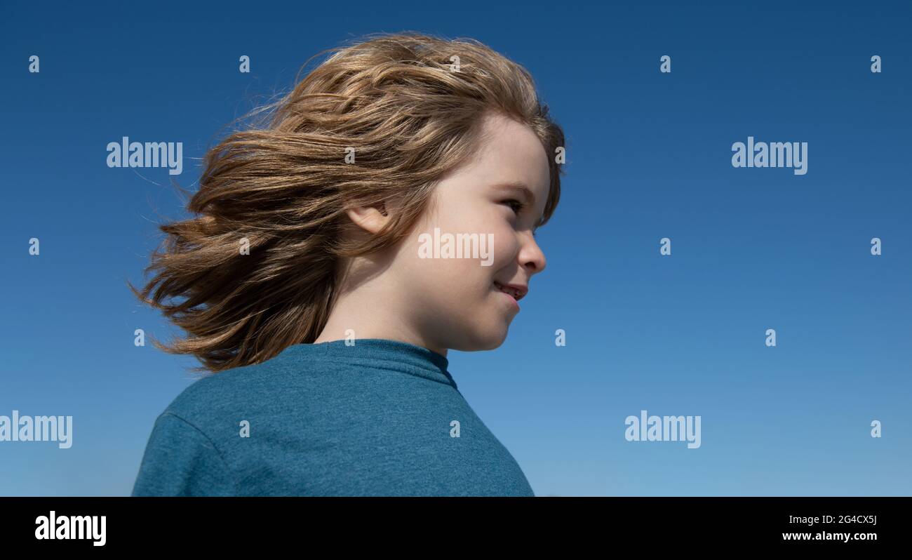 Funny child face on blue sky with copy space, close up. Kids looking ...