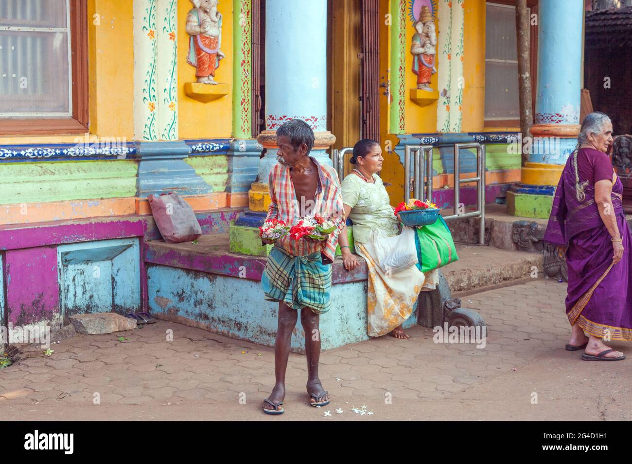 Indian male and female offer puja offering to worshippers at the ...