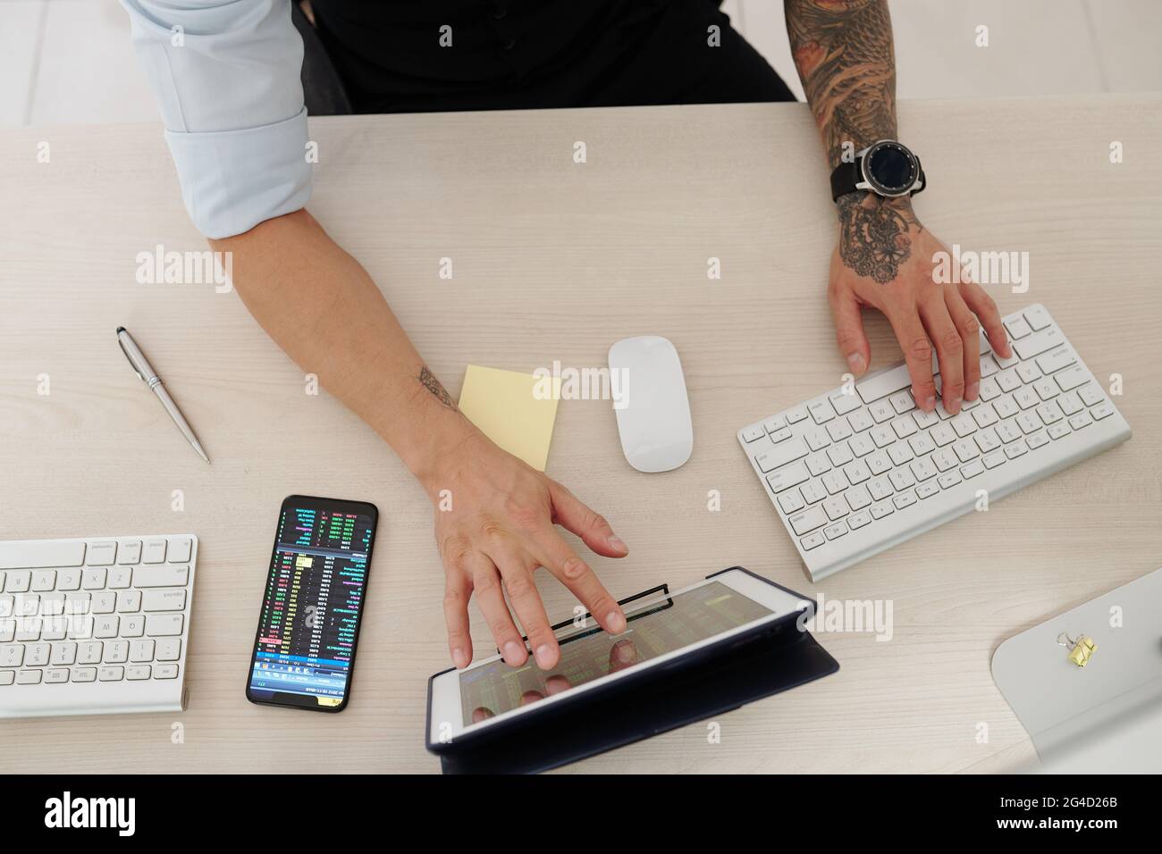 Hands of professional trader working at office desk, typingon keyboard ...