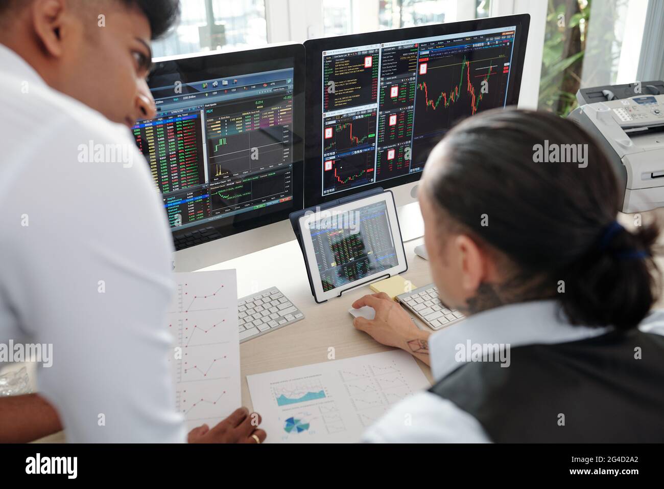 Traders discusing charts and digrams and analyzing stock market data ...