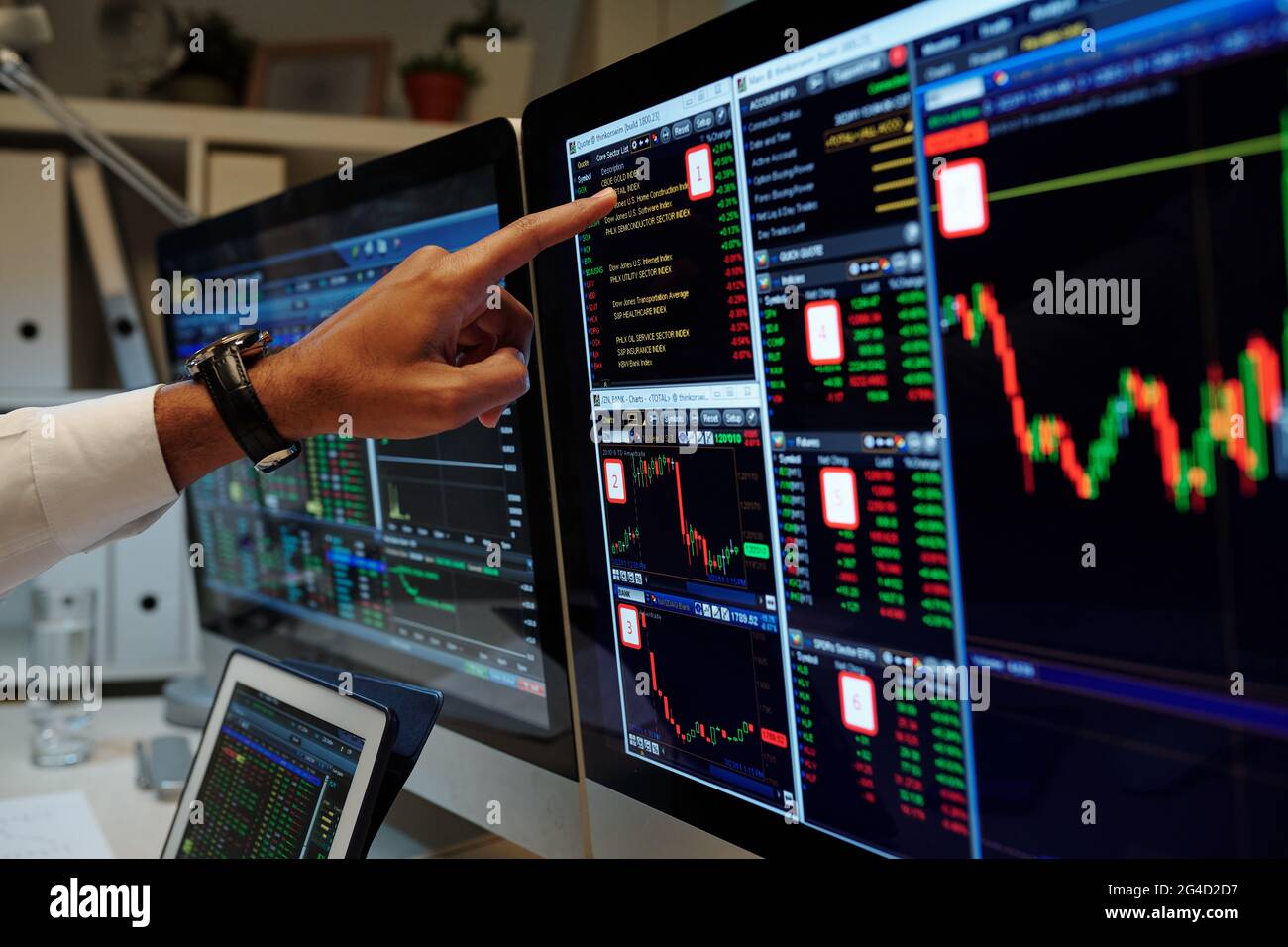 Close-up image of trader is pointing at graphs on computer screen and ...