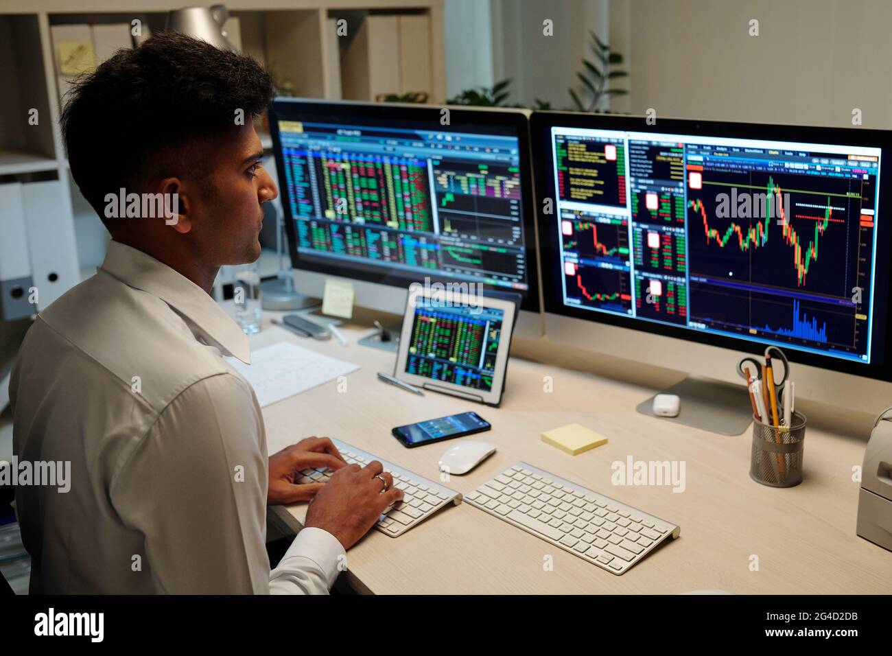 Stock broker working on computer and analyzing charts and prices on ...
