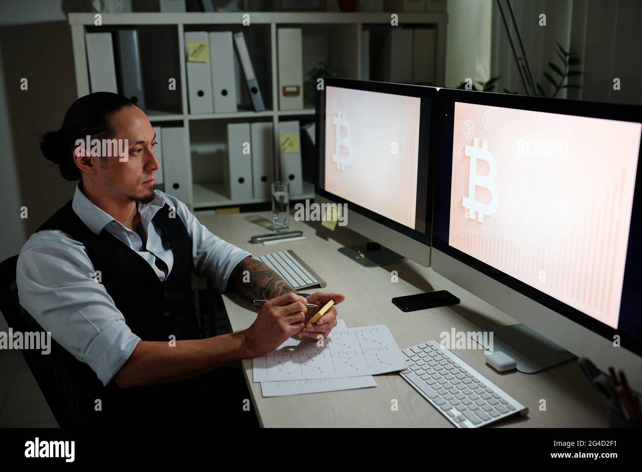 Pensive serious investor looking at inscreasing bitcoin prices chart ...