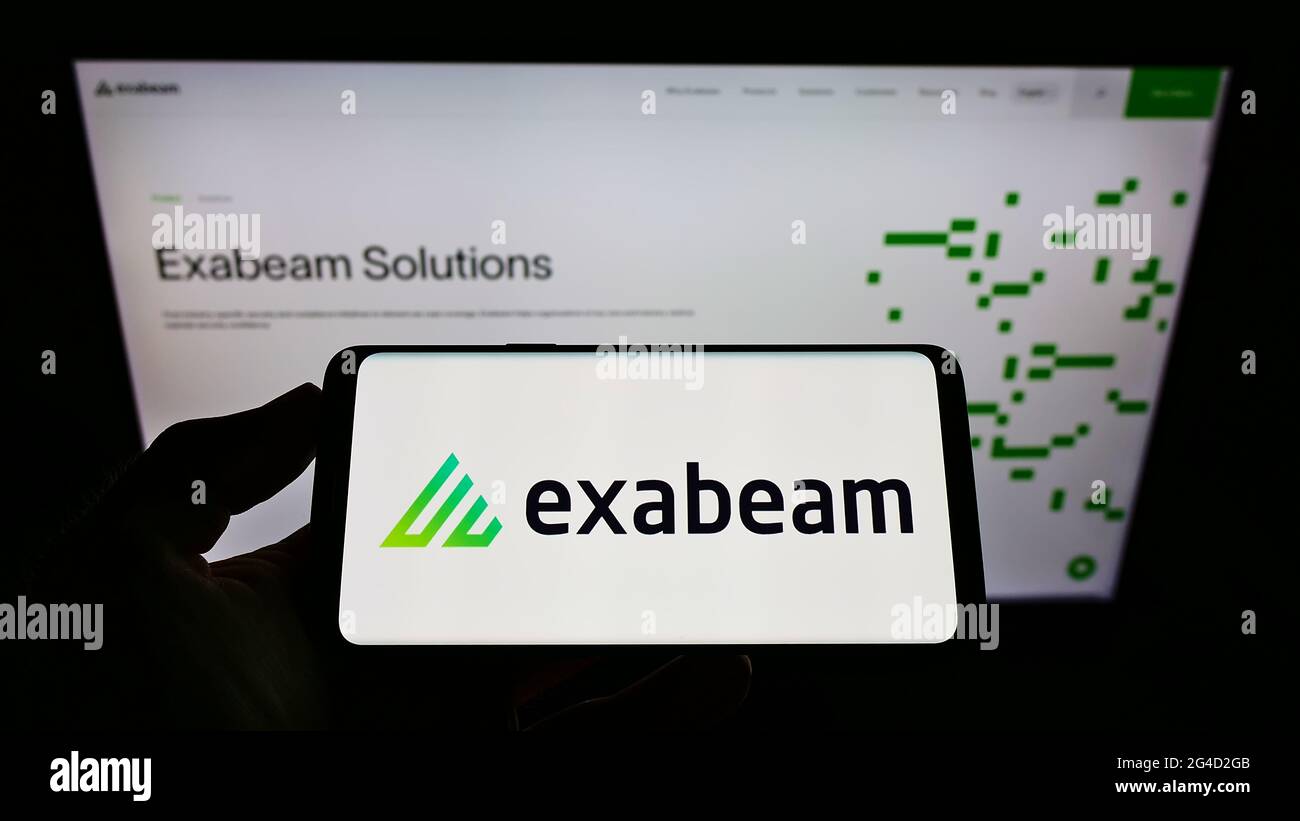 Person holding mobile phone with logo of US cybersecurity company ...