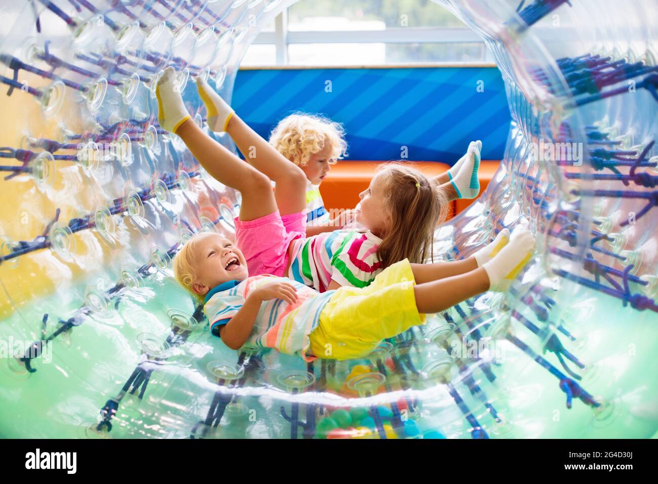 Child in roller wheel jumping on colorful playground trampoline. Kids ...