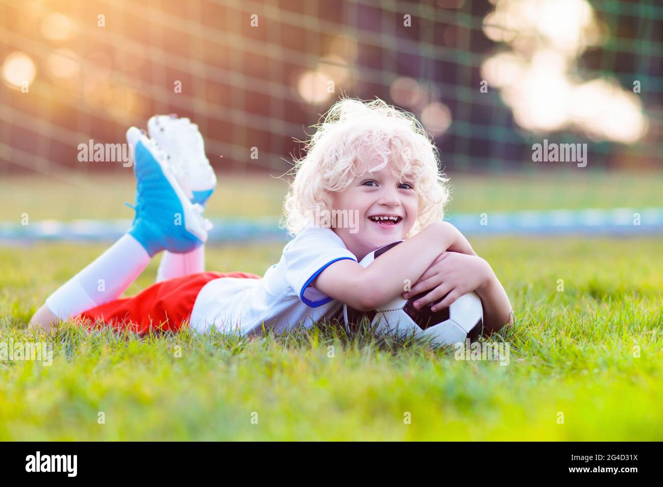 Kids play football on outdoor field. England team fans. Children score ...