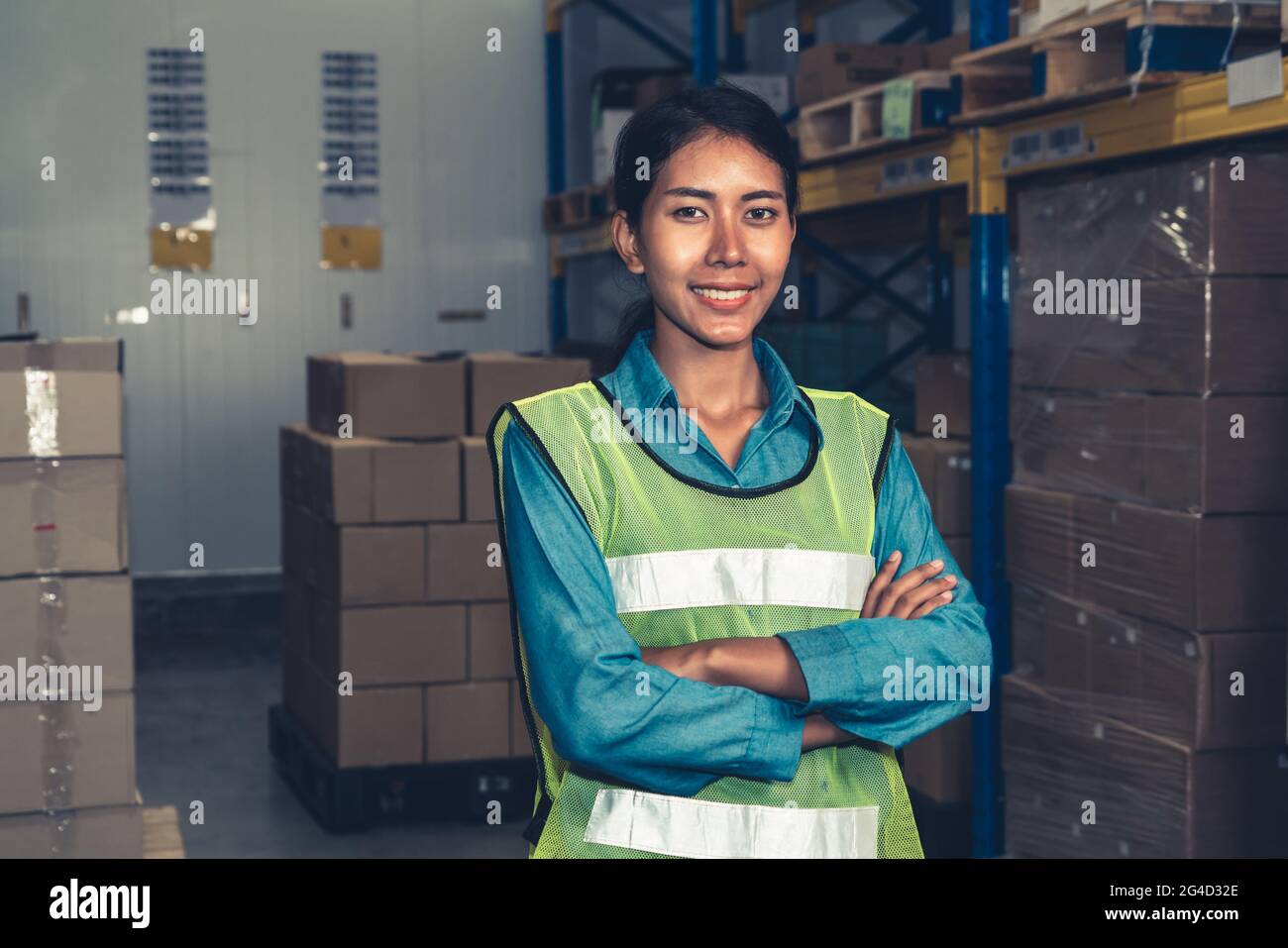 Portrait of young woman warehouse worker smiling in the storehouse ...