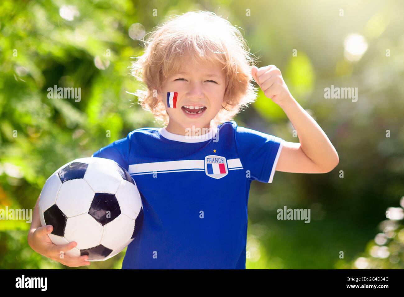 Kids play football on outdoor field. France team fans. Children score a ...