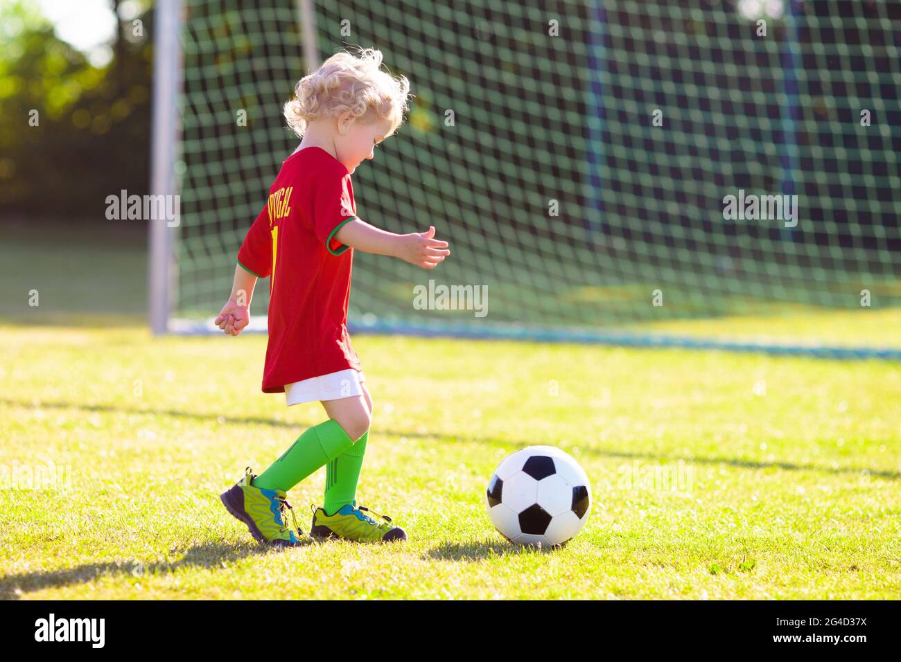 Kids play football on outdoor field. Portugal team fans. Children score ...