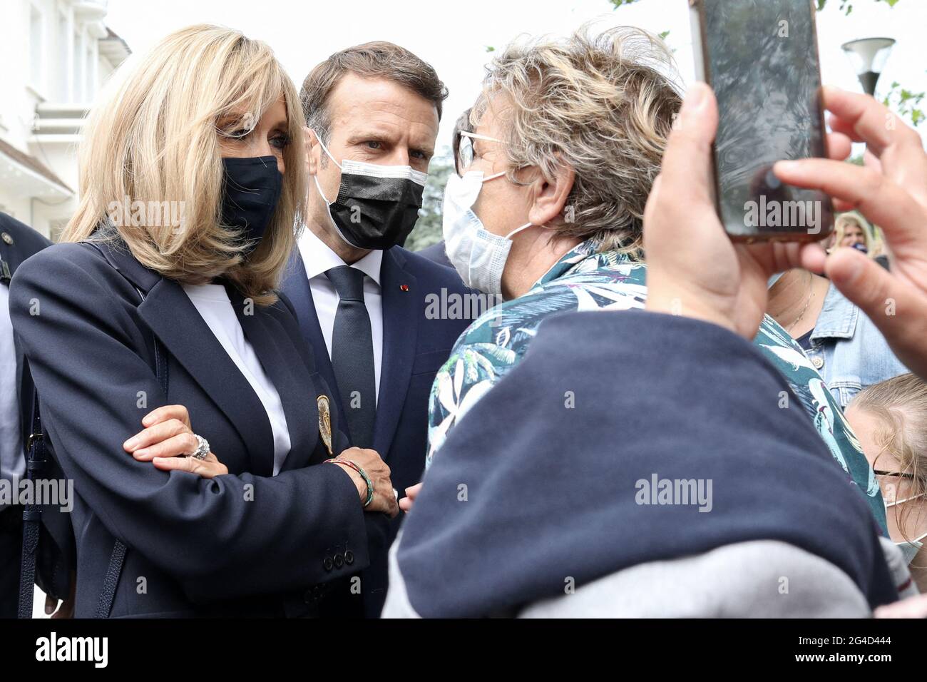 President Emmanuel Macron and wife Brigitte Macron, both wearing a mask ...
