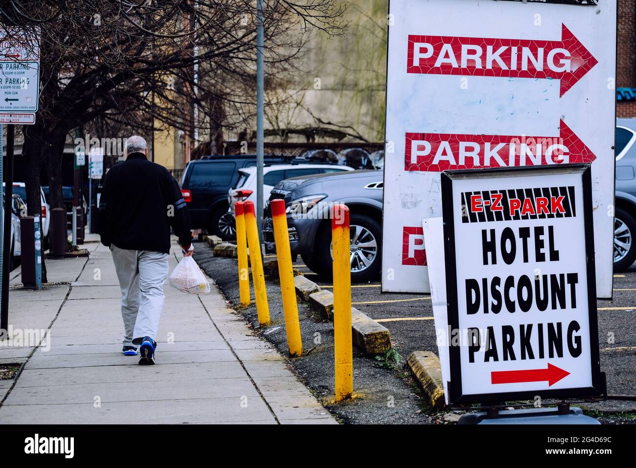 Man walking alongside a parking lot Stock Photo - Alamy