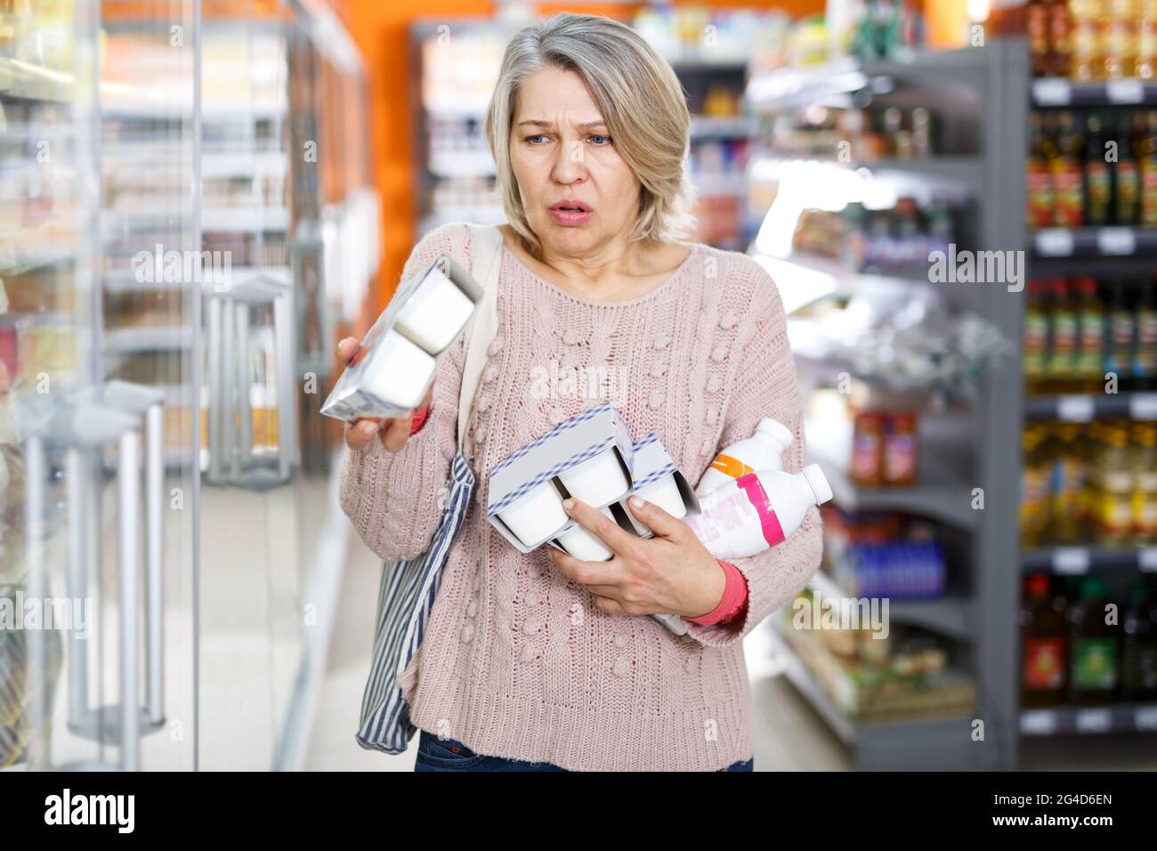 Shocked adult female reading product label Stock Photo - Alamy