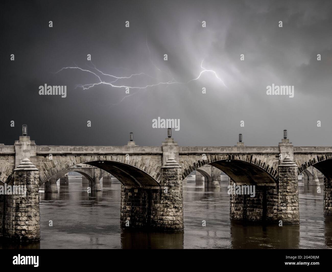 Dramatic view of a stone arch bridge crossing a river and a ...