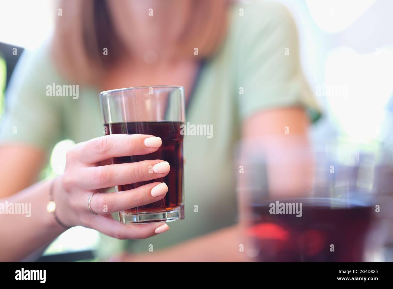 Woman hand holds glass beaker with brown liquid Stock Photo - Alamy